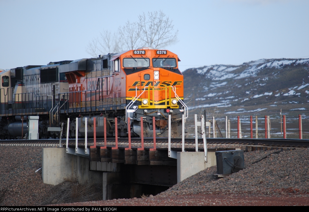 BNSF 6376 enters the west end of the yard as she rolls east with a loaded coal train.